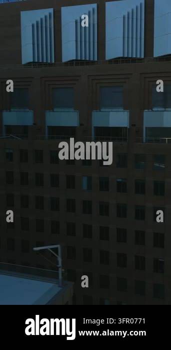 Vertical video: Tight fly around modern high rise downtown buildings ...