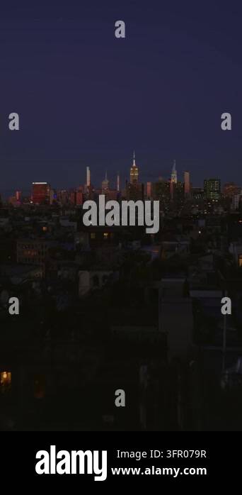 Vertical video: Fly between high rise office buildings in evening city ...