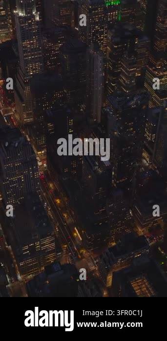 Vertical video: High angle view of night city. Tilt up reveal of ...