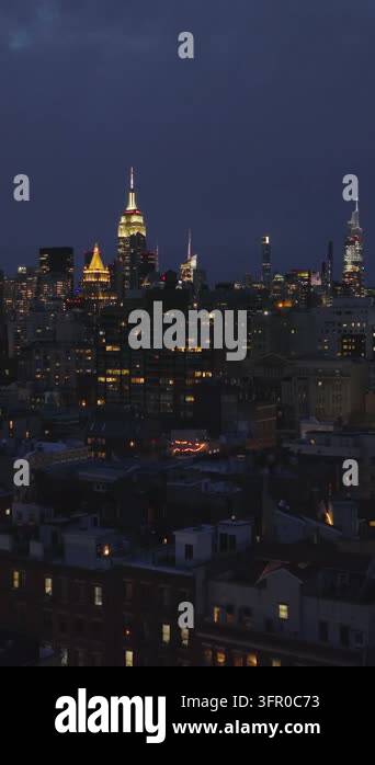Vertical video: Night cityscape. Illuminated towers on top of high rise ...