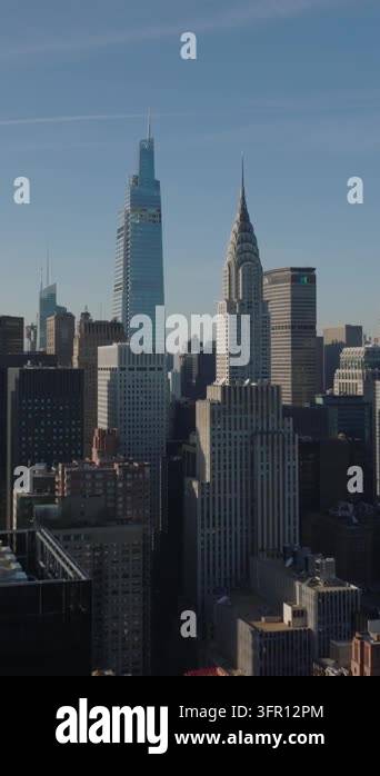 Vertical video: Aerial view of high rise buildings in midtown. One ...