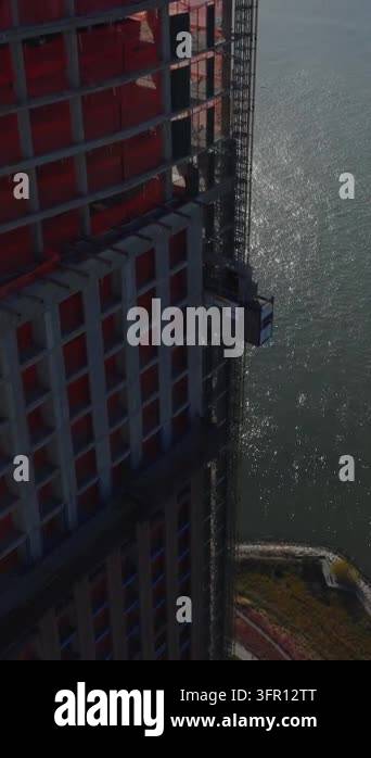 Vertical video: Aerial descending footage of high rise building ...