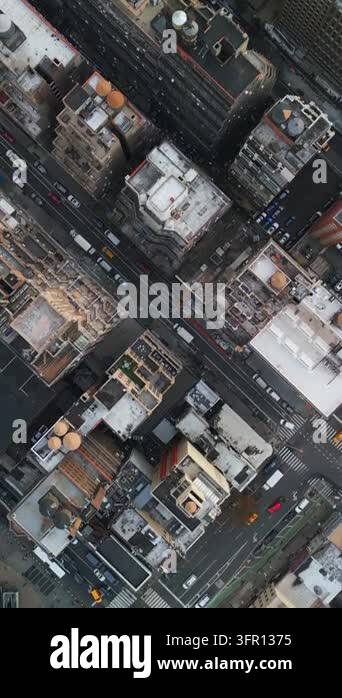 Vertical video: Fly above blocks of high rise buildings in metropolis ...