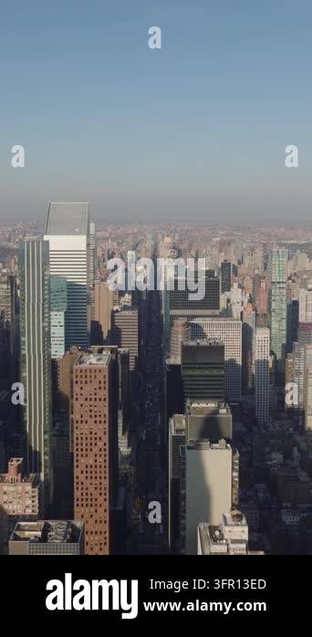 Vertical video: Aerial view of high rise office buildings lit by ...