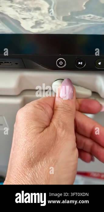 A manicured female hand turns the latch to open the fold-down tray ...