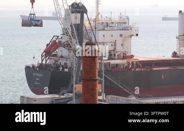 Large cargo ship docked at port behind a brick chimney Stock Video ...