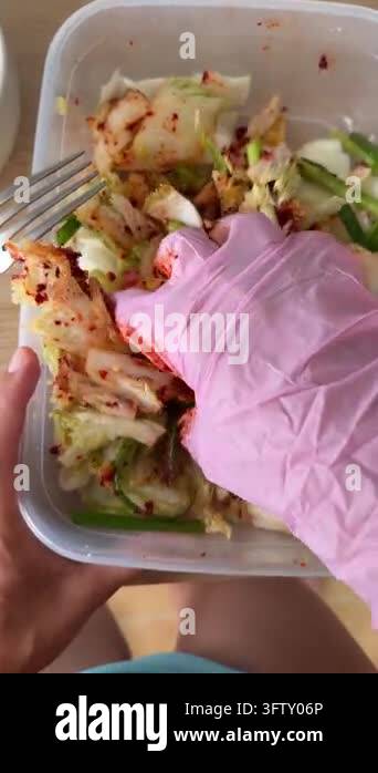Close overhead motion of pink disposable glove pressing, folding, and ...