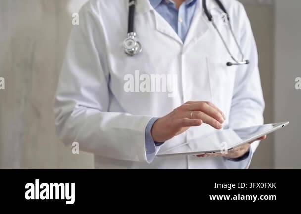 Doctor woman wearing lab coat and stethoscope using tablet computer in ...