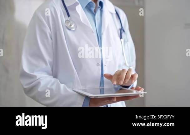 Doctor woman wearing lab coat and stethoscope using tablet computer in ...