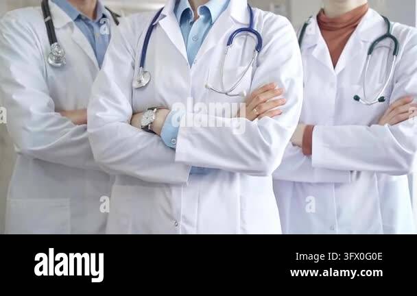 Group of doctors wearing white coats and stethoscopes standing with ...