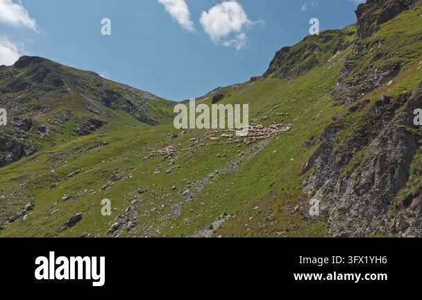 Drone flight advances into remote green pass bordered by sharp rock ...