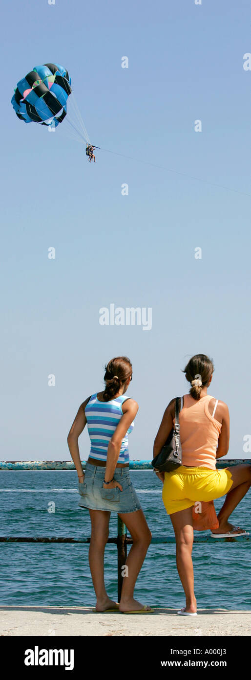 parachute paragliding behind a beach parasailing rainbow red yellow ...