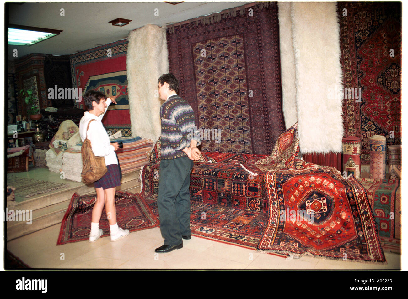 A woman tourist bargaining with a rug salesman in Turkey Stock Photo ...