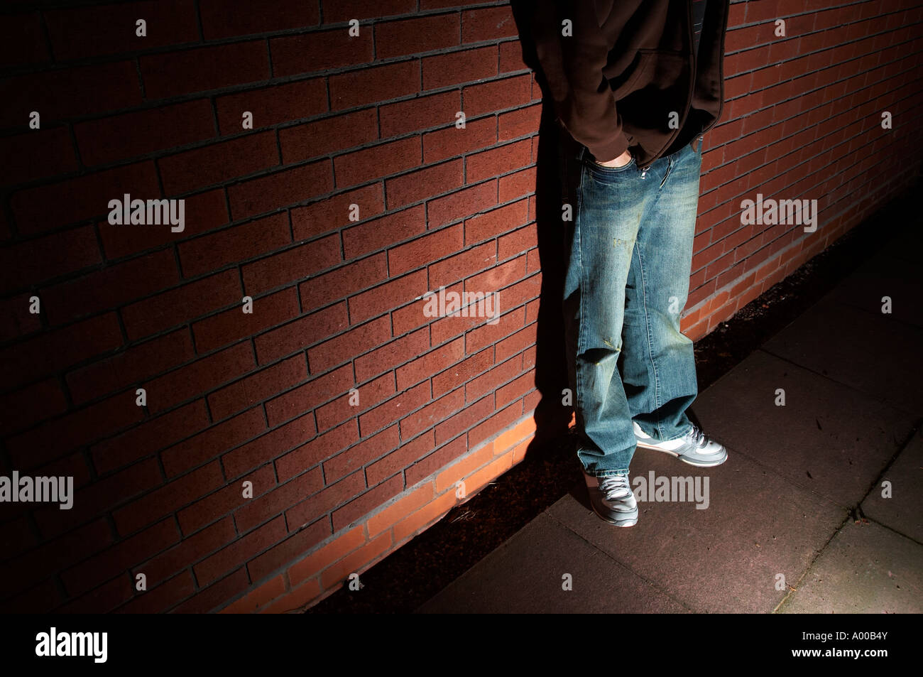 figure against brick wall with spotlight Stock Photo - Alamy