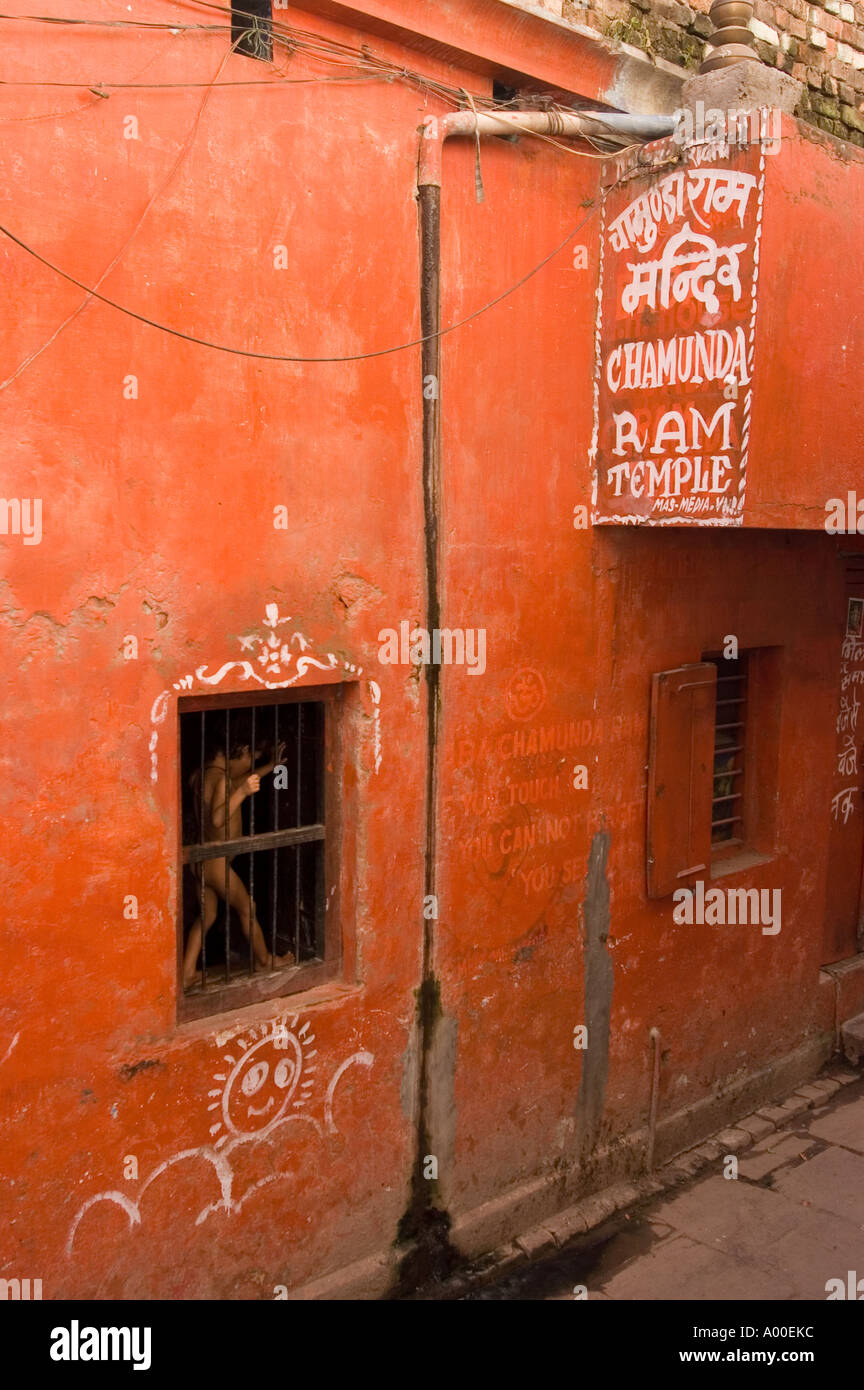 Small child looking through a barred window of the red Chamunda Ram ...