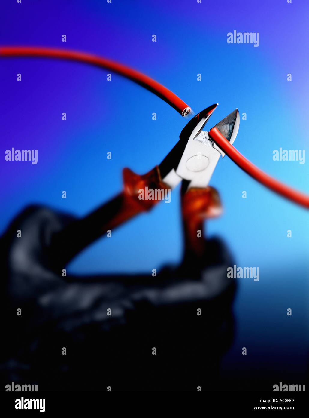 Gloved hand cutting red wire with wire cutters Stock Photo - Alamy