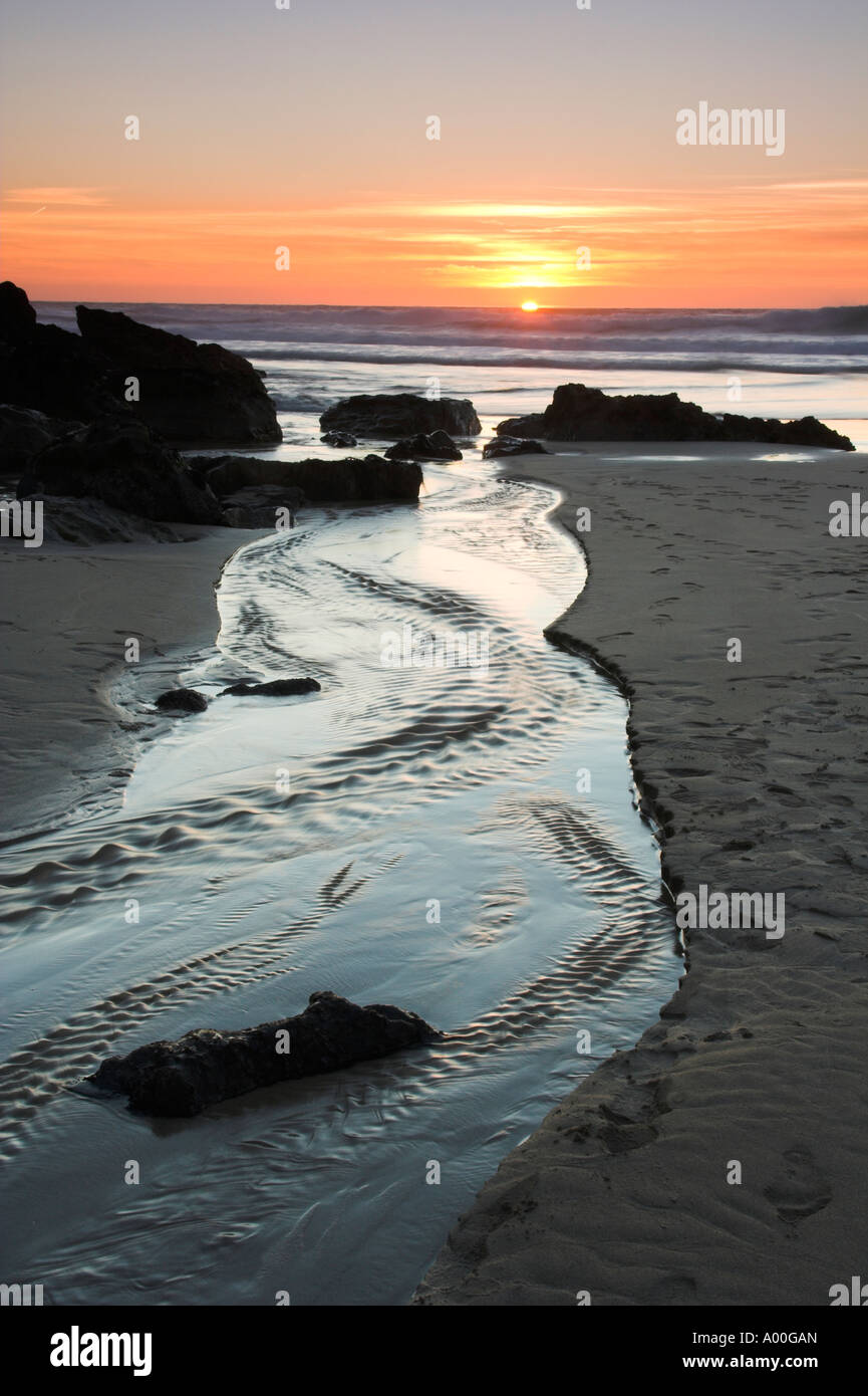 Small river on the beach winding its way to the sea at Chapel Porth ...