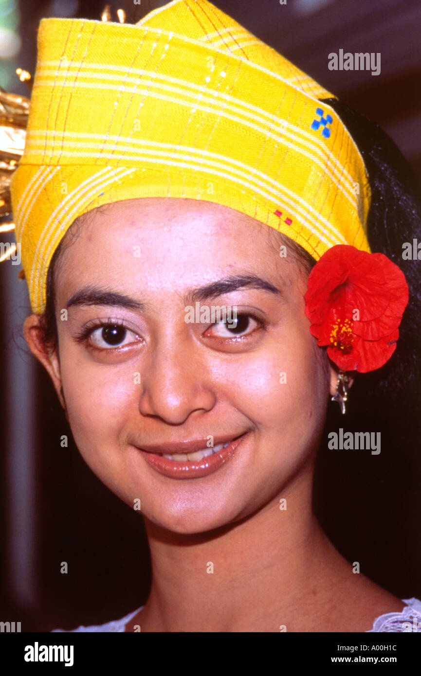 pretty smiling balinese girl in yellow head wear with orchid in her ...