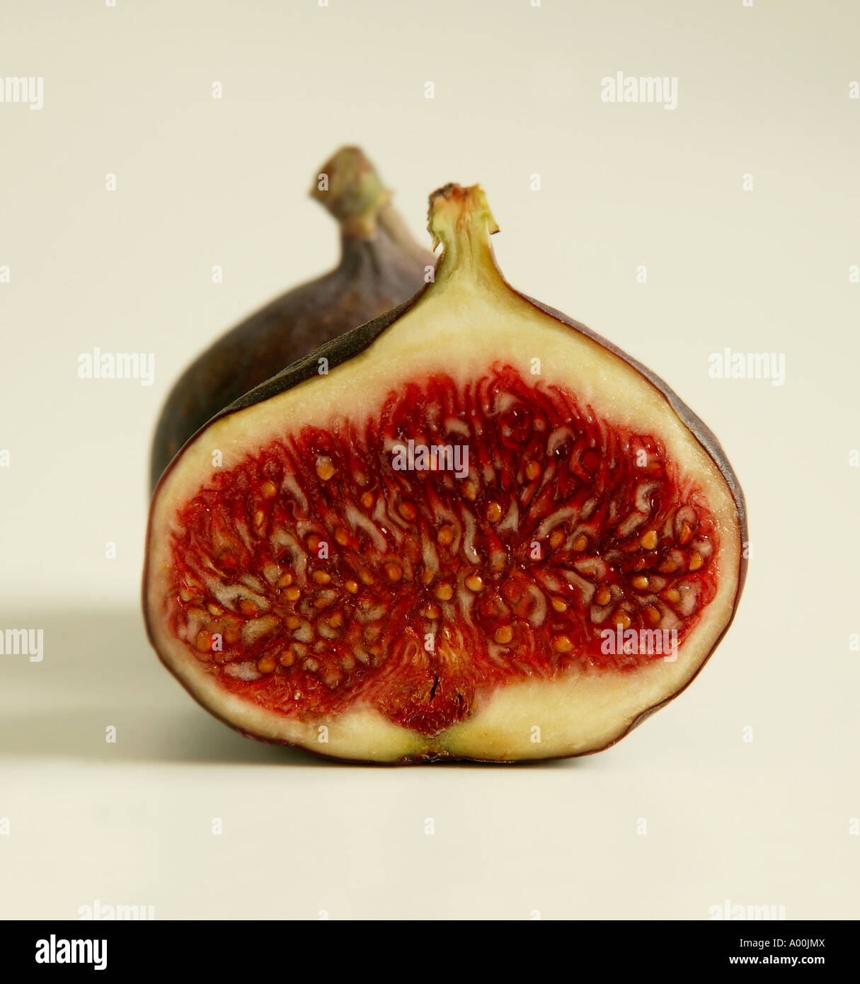 figs on studio white background with one single fruit cut to show ...