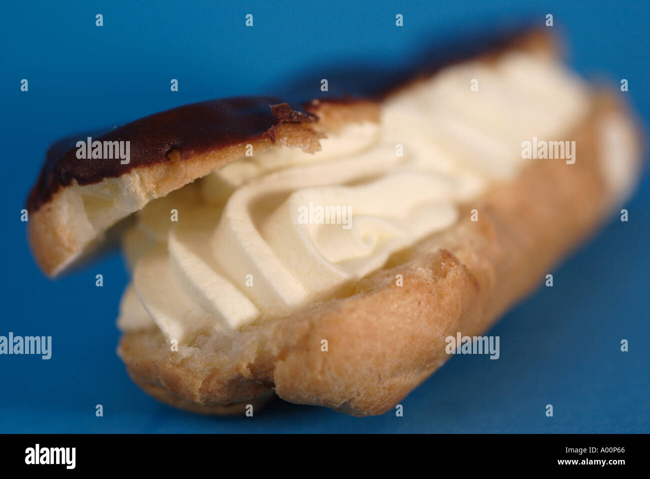 chocolate eclair on blue background Stock Photo - Alamy