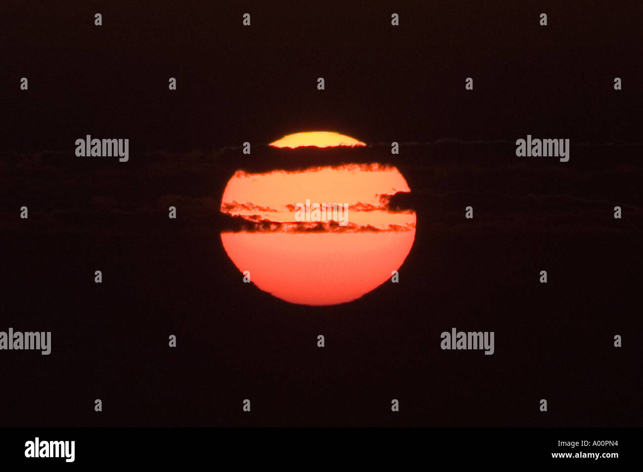 Zoom of sun plate during sunset with clouds Stock Photo - Alamy