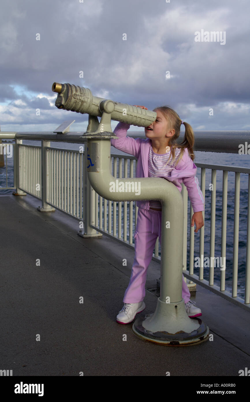 girl looking thru wrong end of telescope Stock Photo - Alamy
