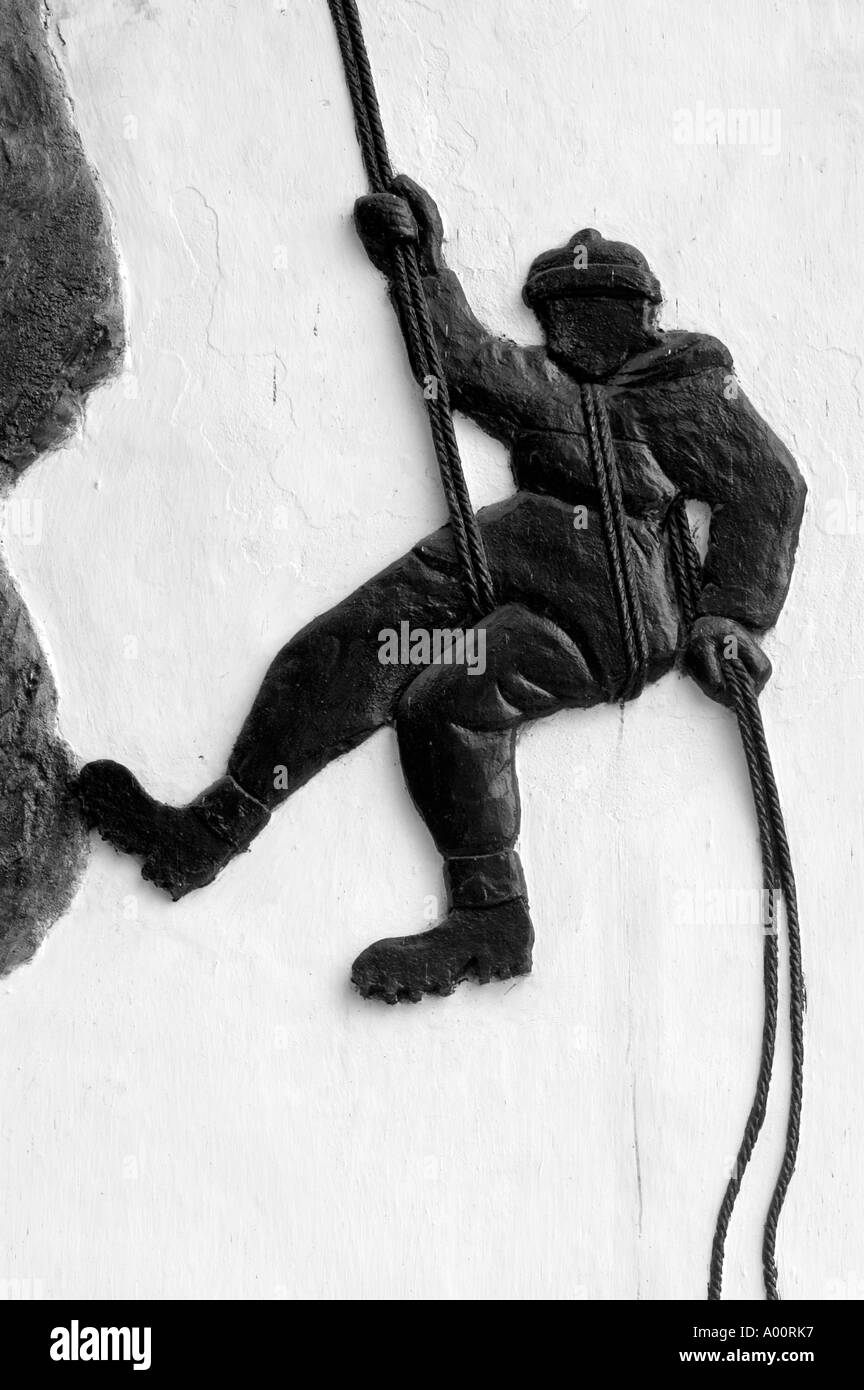Bas relief of an Alpinist descending from a rock by rope at the ...