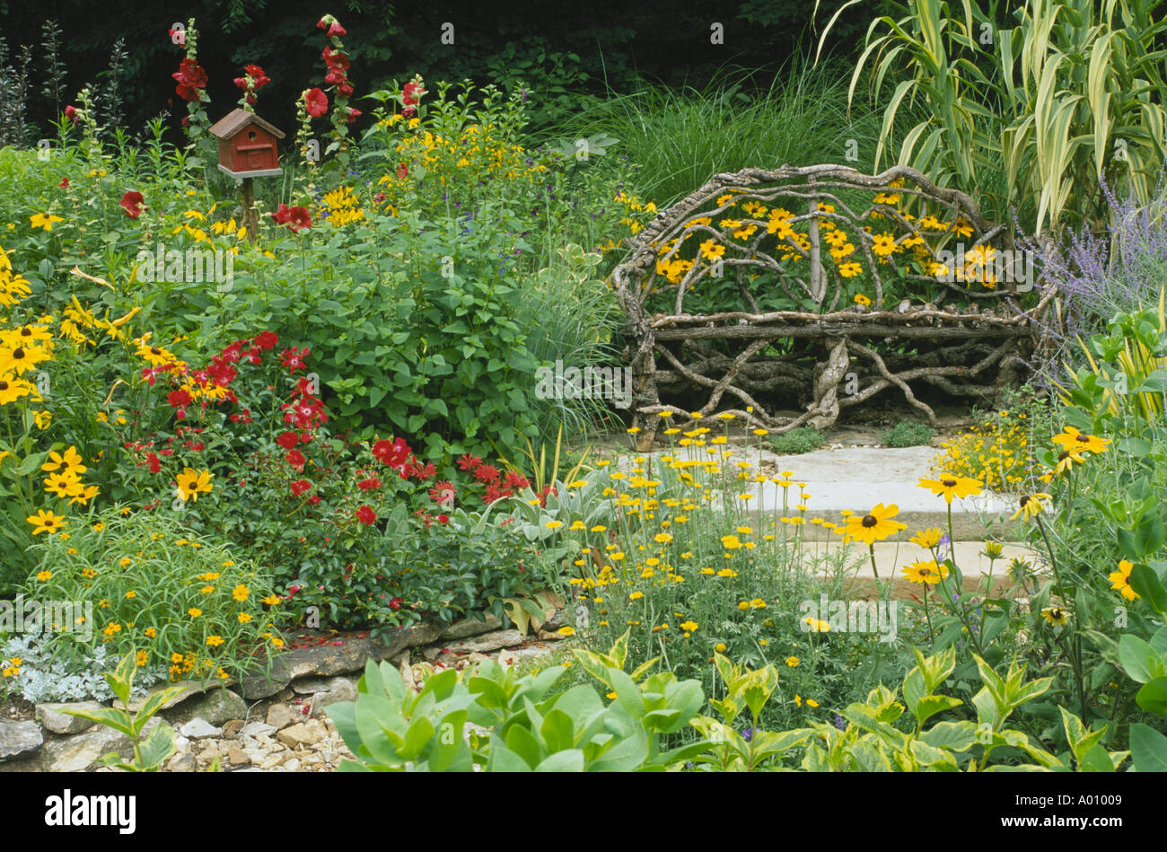 Rustic handmade grapevine bench by stone steps and birdhouse in summer ...