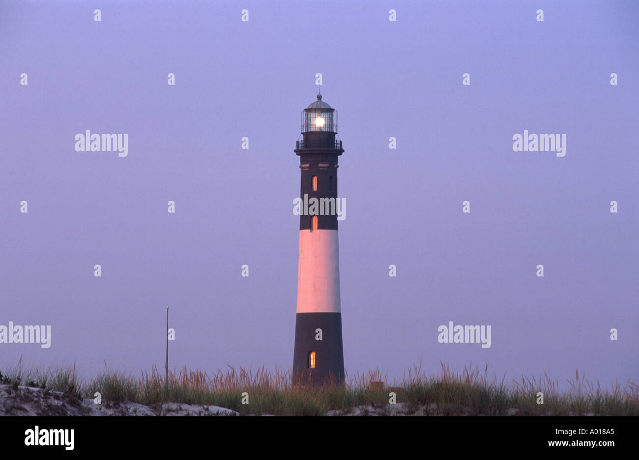 Lighthouse in blue sky with sunset reflections on Fire Island, Long ...