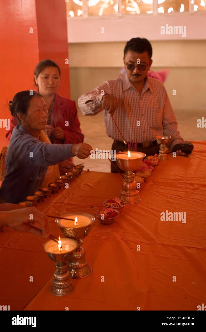 Buddhist pilgrims preparing butter lamps and incenses inside statue of ...