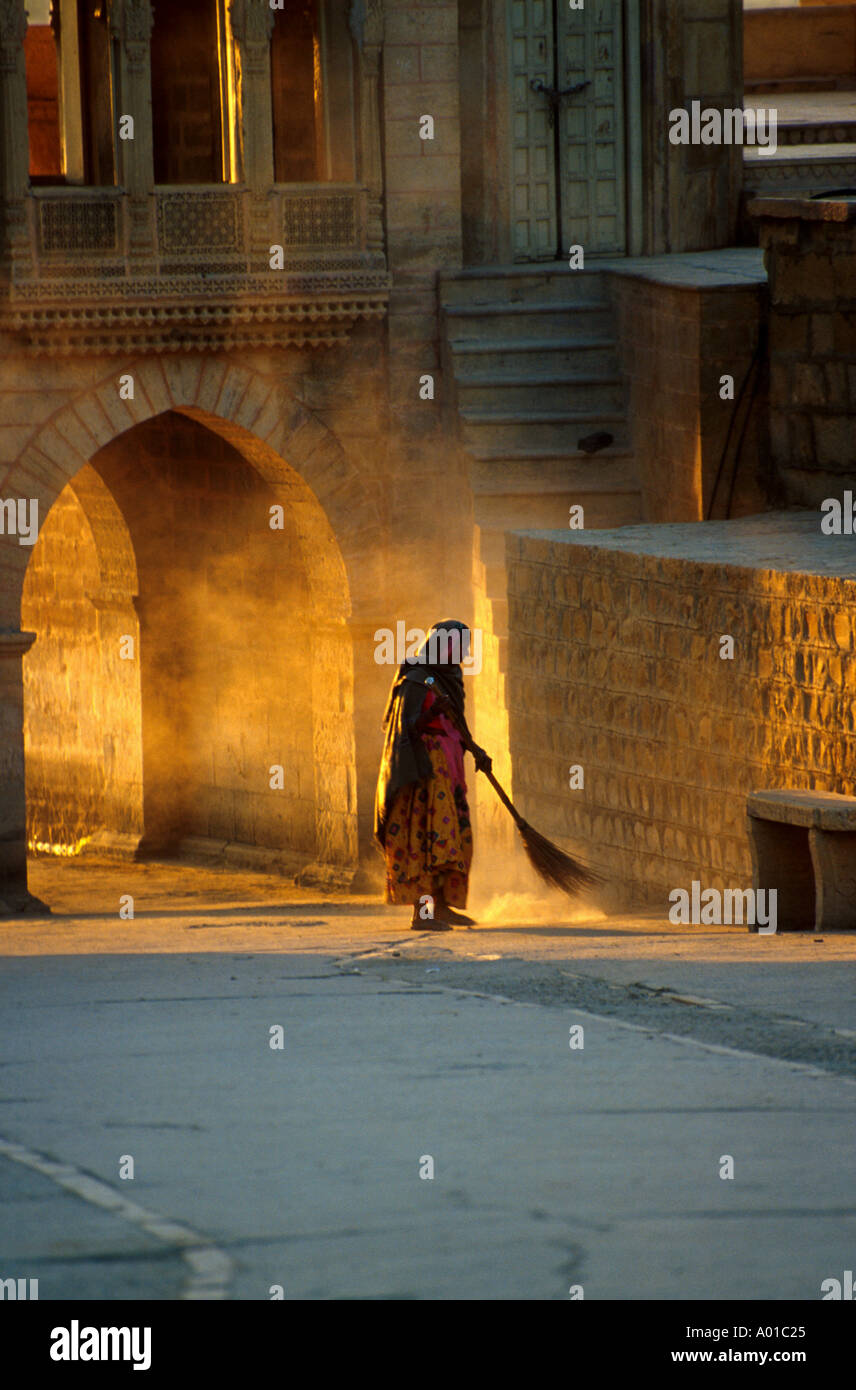 Dawn Sweeper. An Indian woman sweeping dust around a Hindu temple at ...