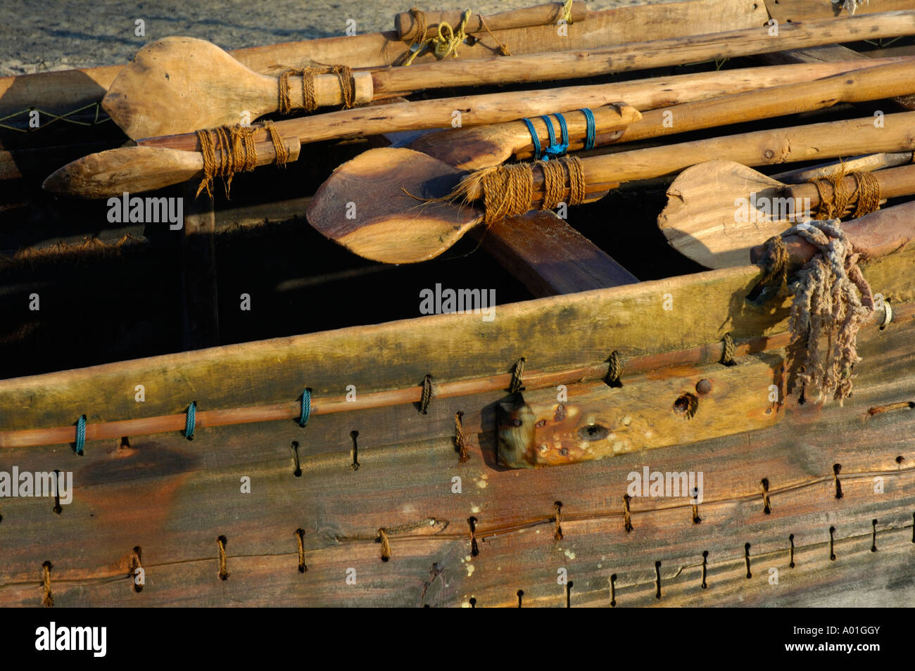 Detail of a sewed wooden fishing boat with paddles on the beach of ...