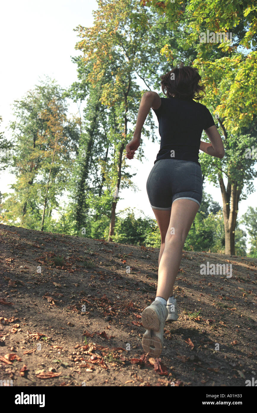 Young woman jogging in park rear view Stock Photo - Alamy