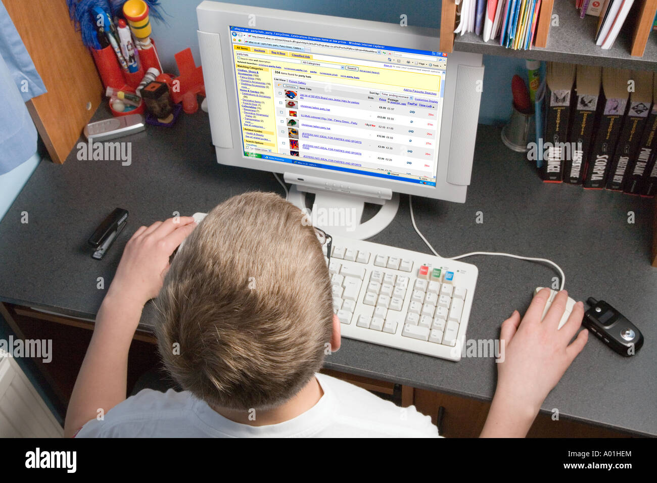 12 year old white boy using eBay via internet on PC computer at home ...