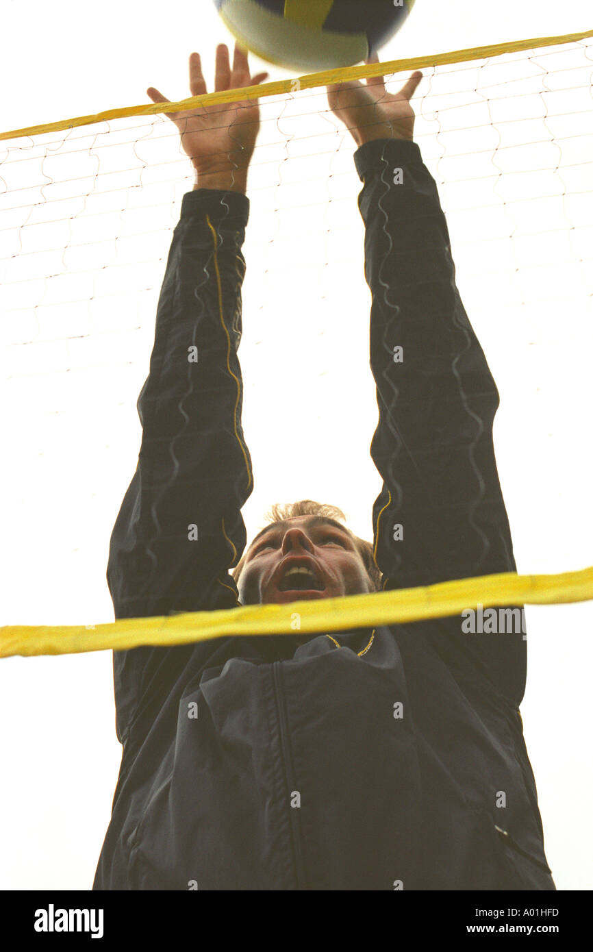 Volleyball player jumping in defense at the net Stock Photo - Alamy