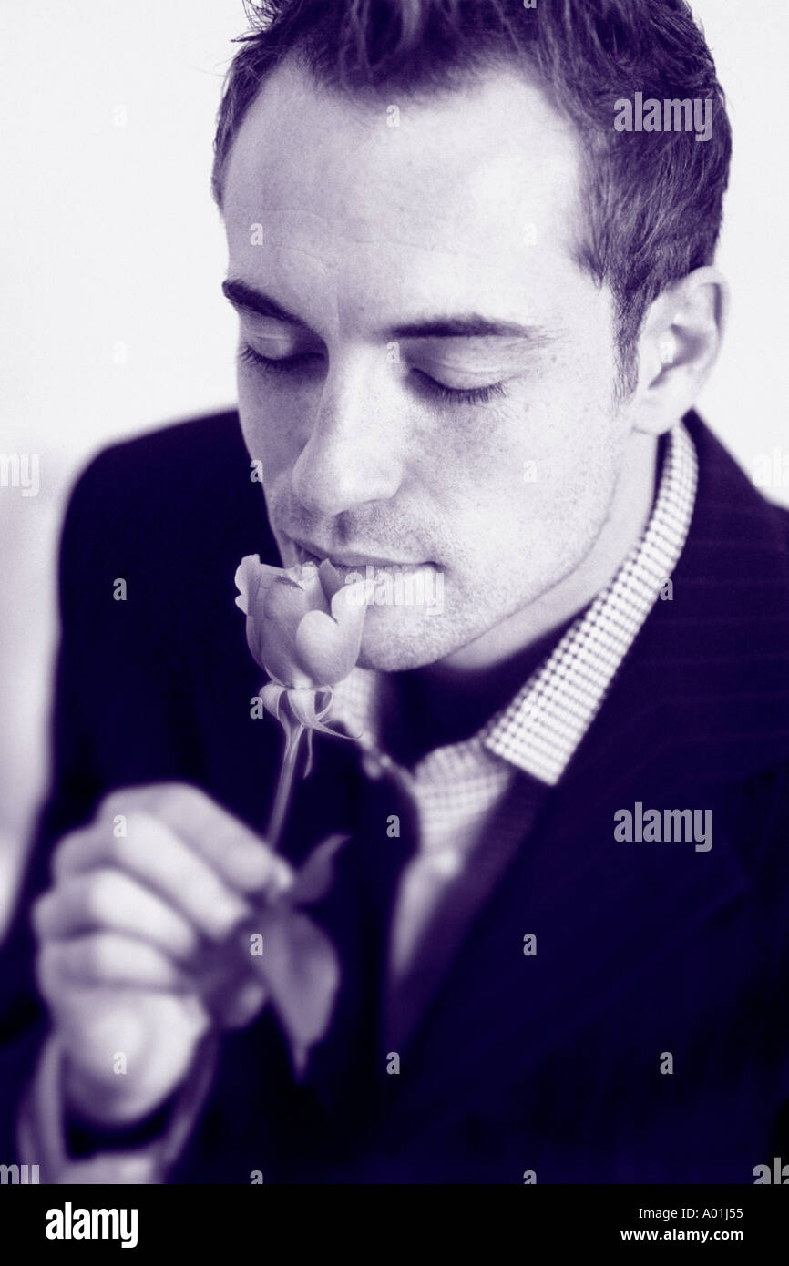 Close up of a man smelling a rose Stock Photo - Alamy