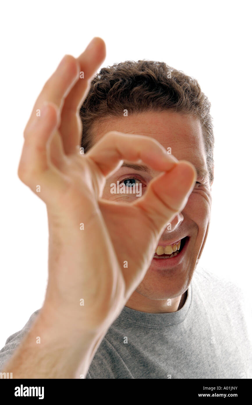 Studio shot on white background of male looking through ok symbol made ...