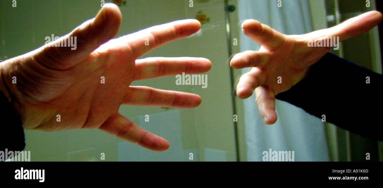 Hand stretching out to grasp another hand reflected in mirror Stock ...