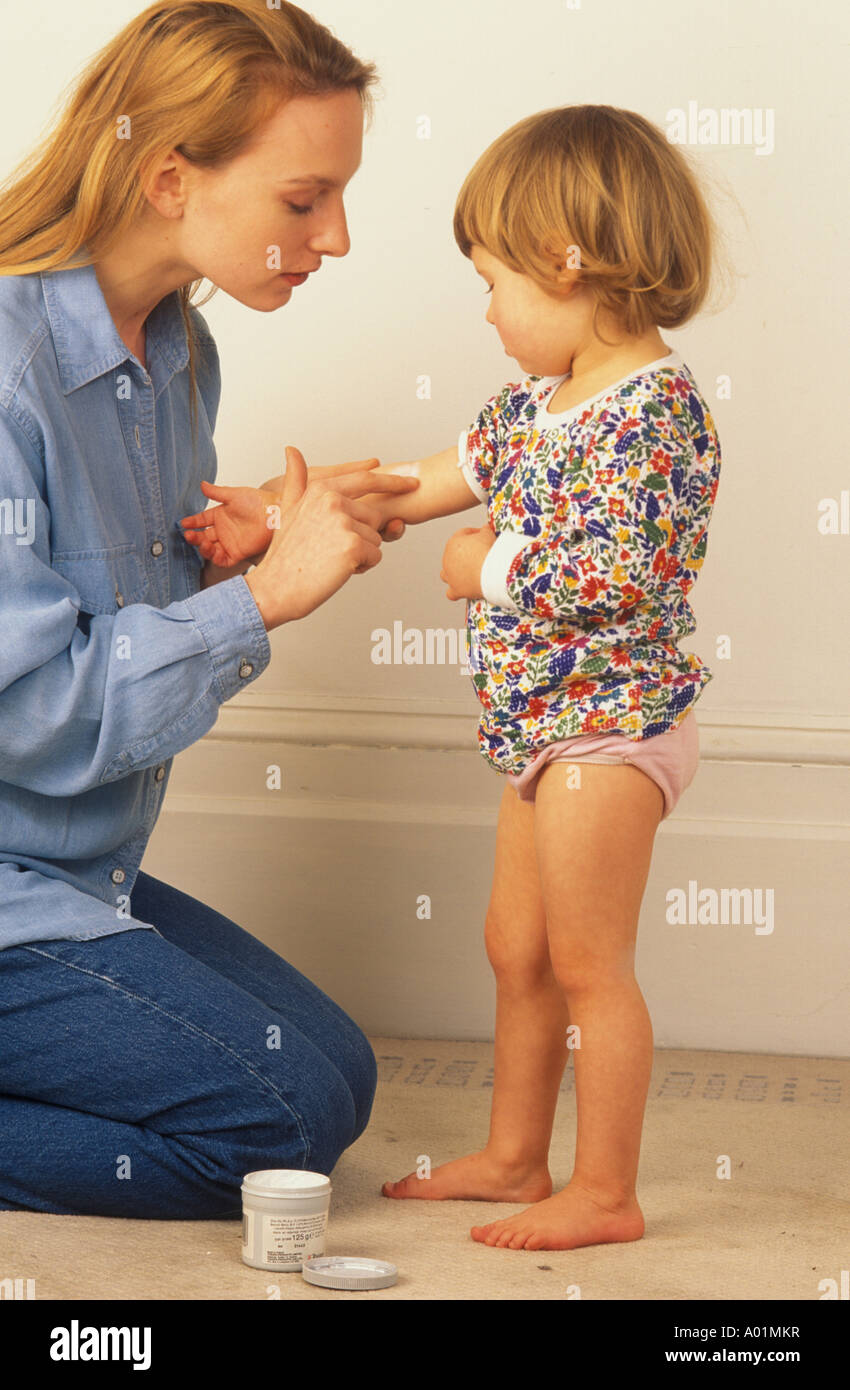 mother rubbing cream on toddler Stock Photo - Alamy