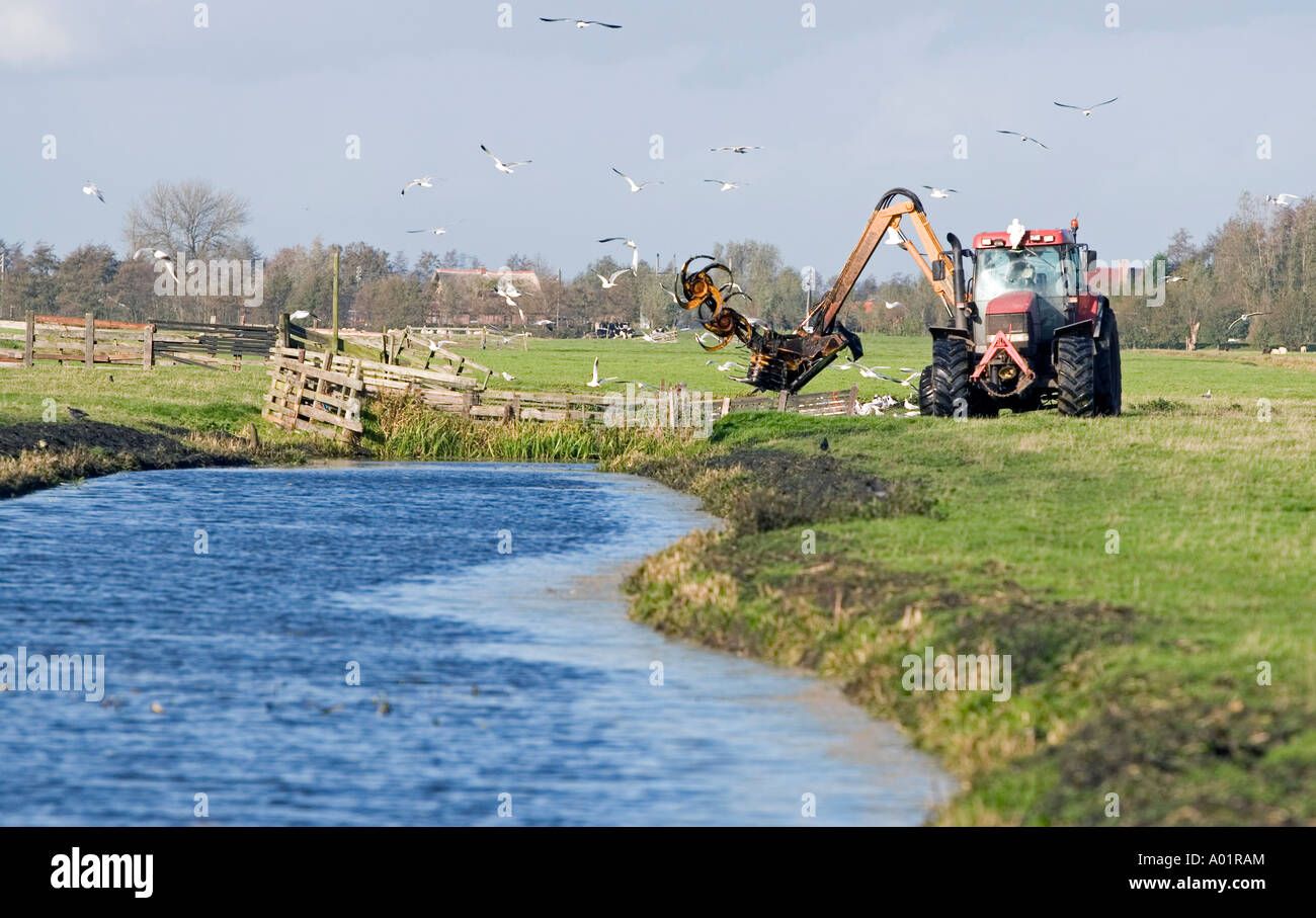 Tractor digging out a waterway, farming in Southern-Holland, The ...