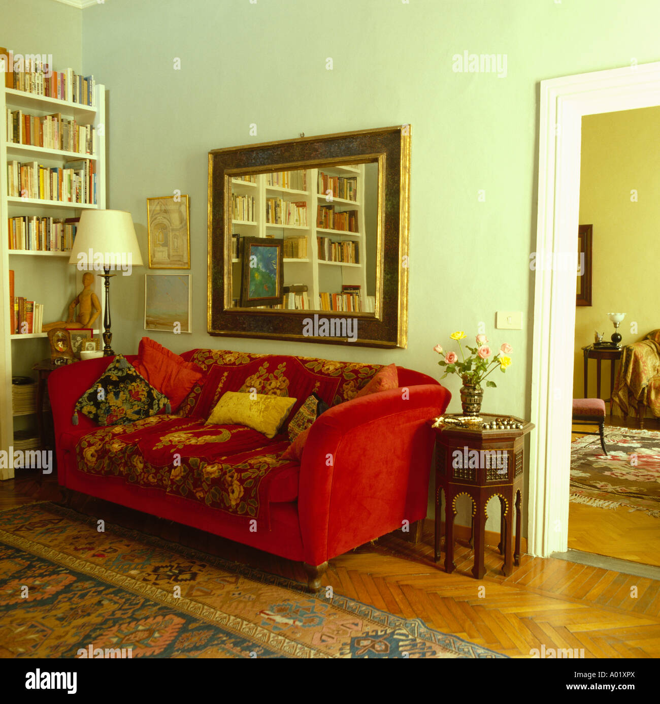 Red upholstered sofa with carpet throw in traditional livingroom with ...