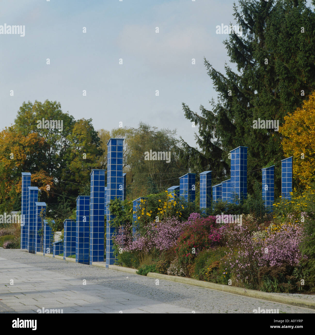 Blue ceramic pillar sculptures in garden border Stock Photo - Alamy
