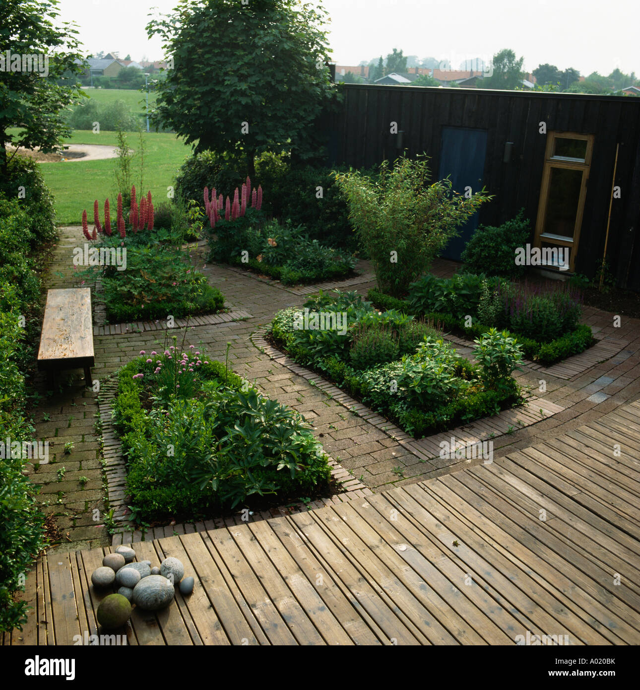 Decking and paving with rectangular flower beds in country garden Stock ...