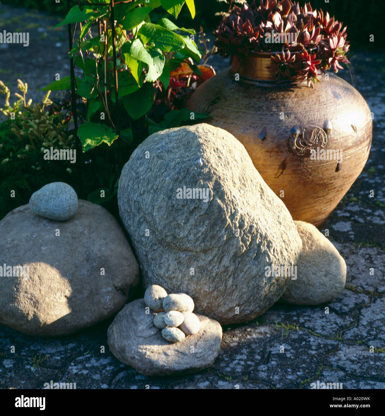 Close-up of smooth, rounded boulders with pebbles and terracotta pot ...