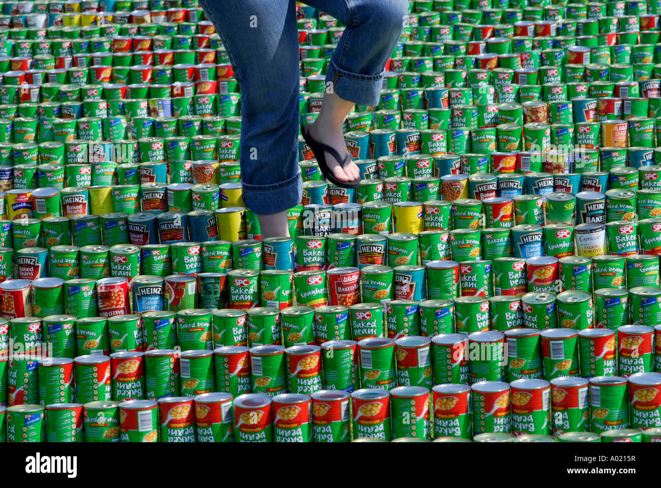 Person stepping between rows of cans of baked beans arranged into a ...
