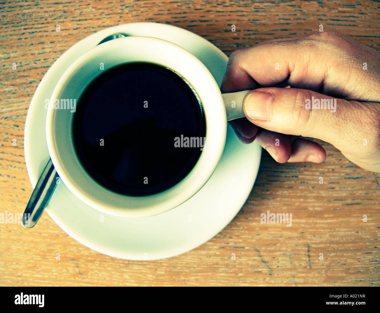 Overhead view of hand holding a coffee cup Stock Photo - Alamy