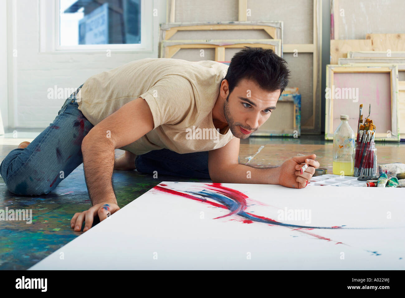 Artist painting on canvas on studio floor Stock Photo - Alamy