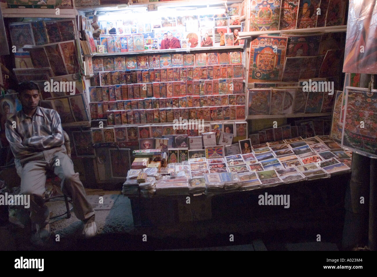 Nigh scene of street shop selling buddhist postcards with Indian clerk ...