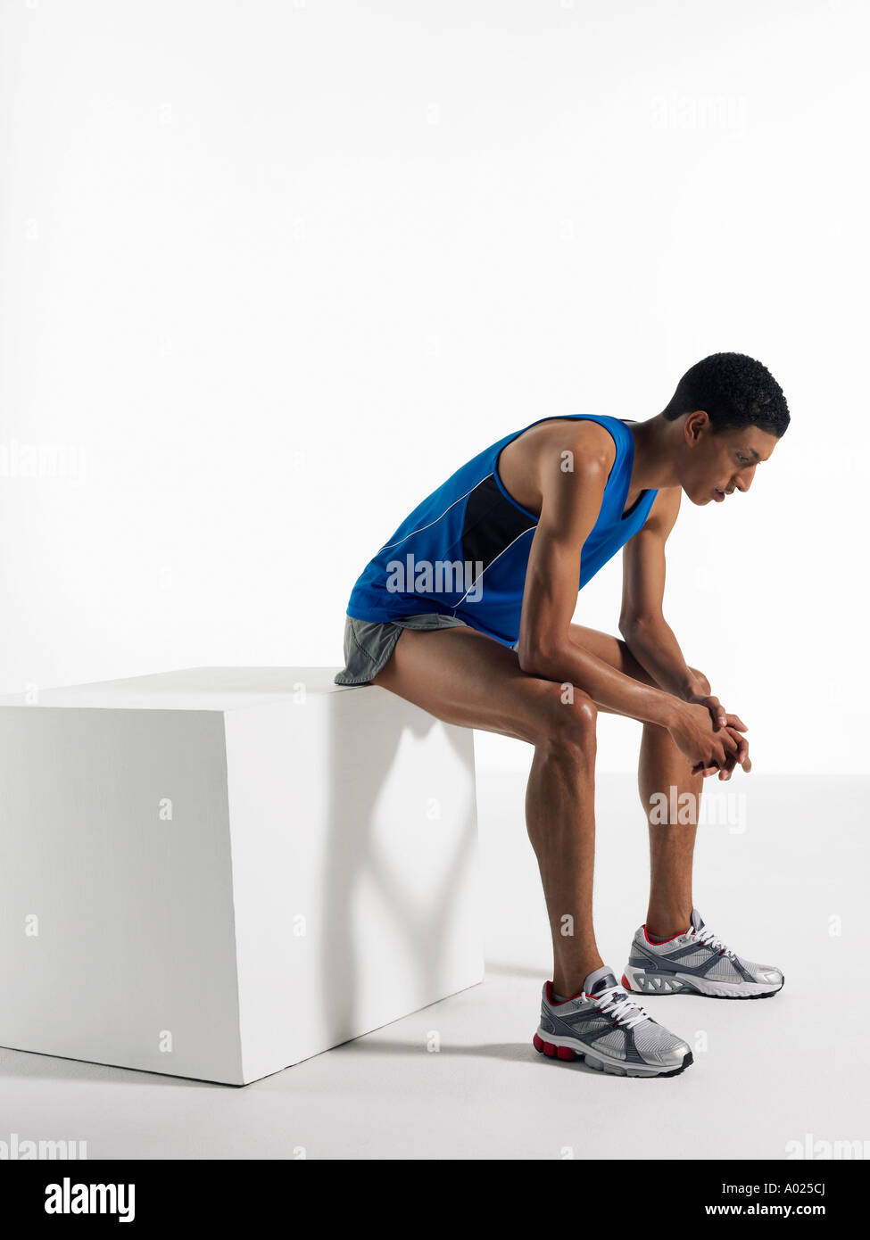Athlete sitting on box, side view Stock Photo - Alamy