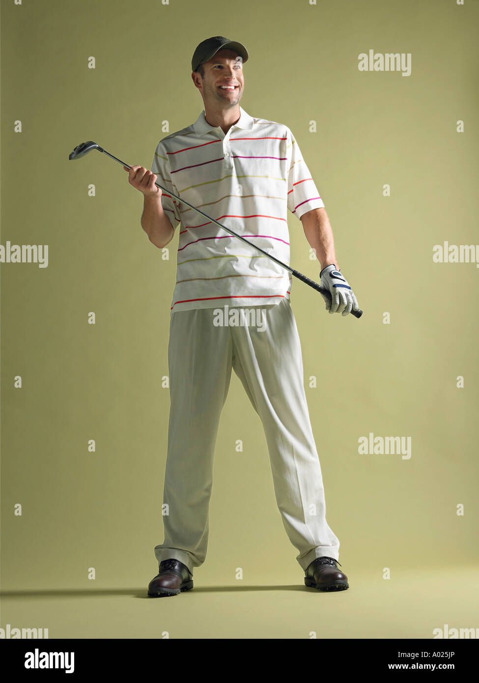 Golfer standing holding club Stock Photo - Alamy